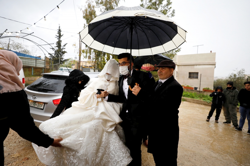 Palestinian groom walks with his bride on their wedding day in the ...